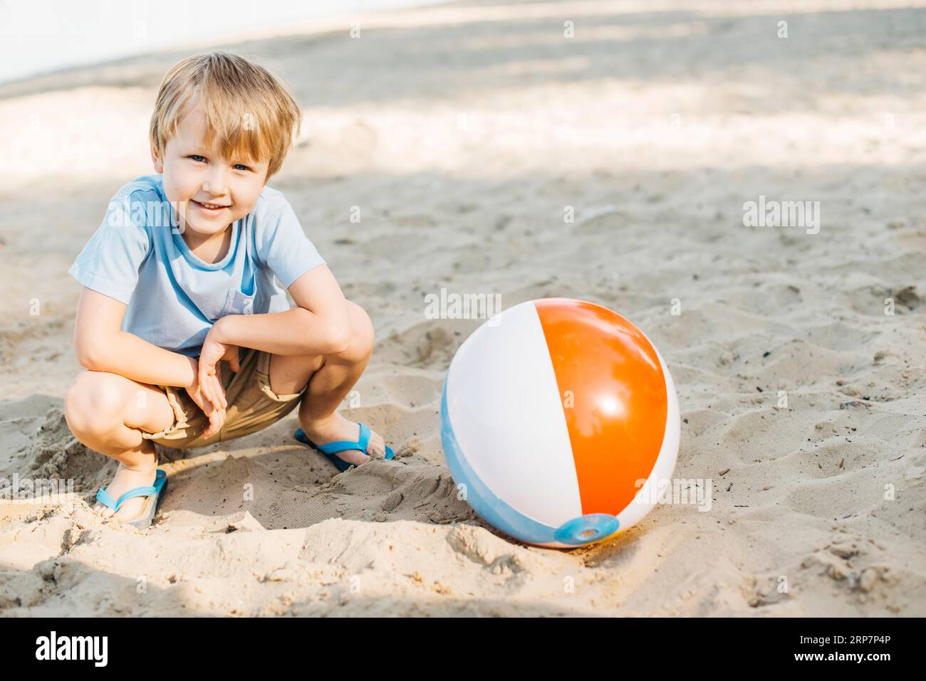 Playful kid sitting wind ball Stock Photo - Alamy