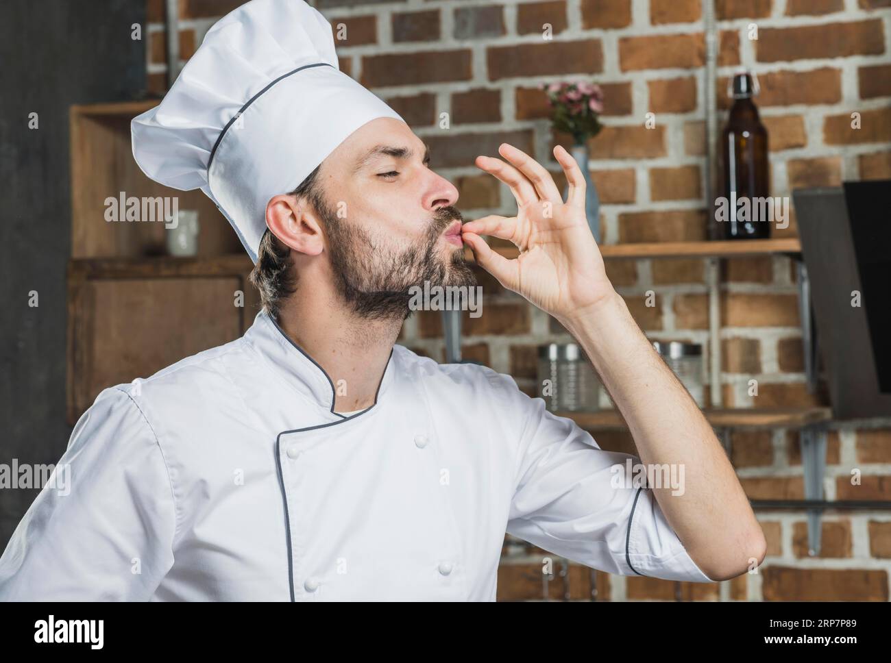 Professional male chef showing sign delicious Stock Photo - Alamy