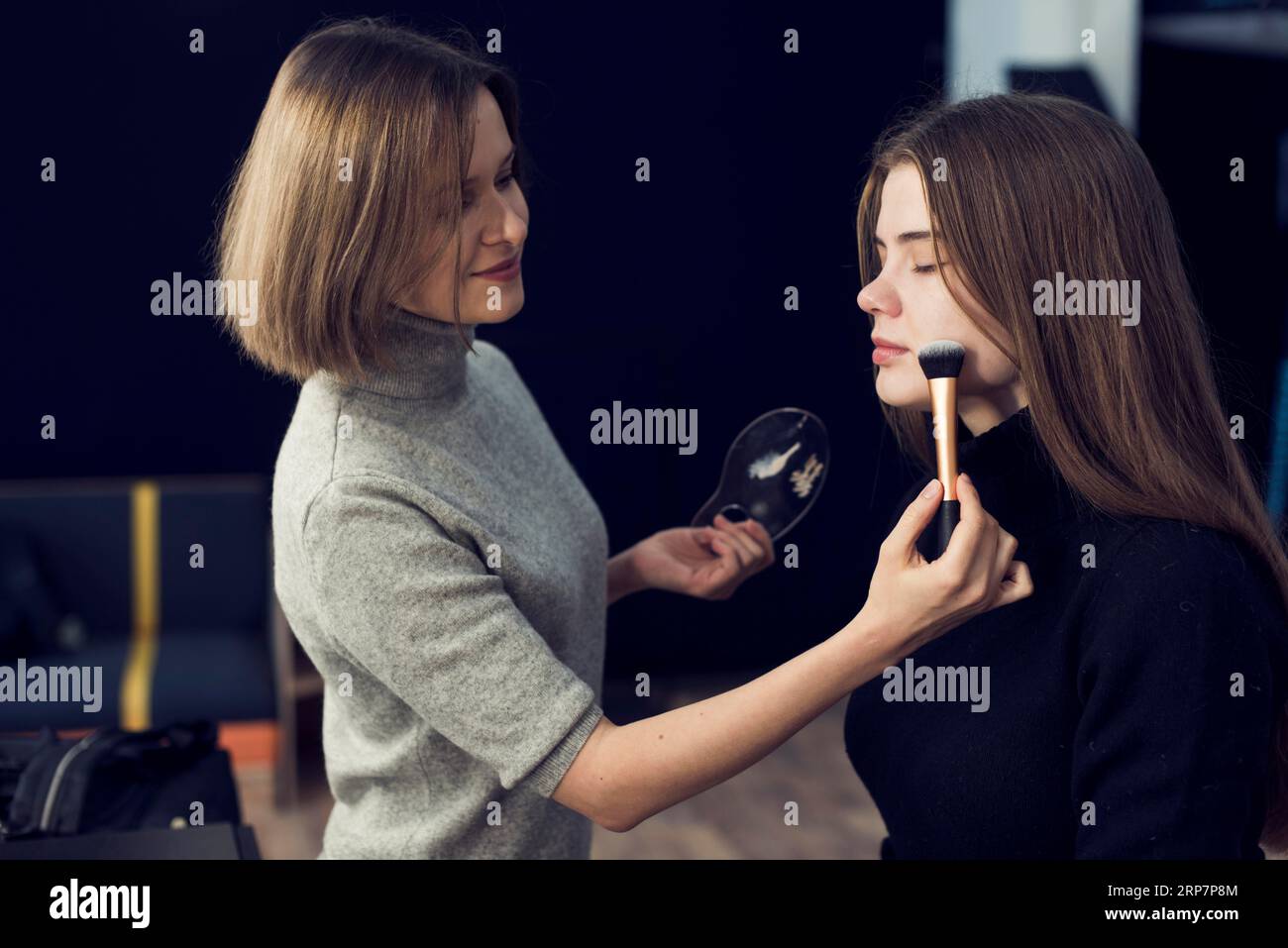 Side view makeup artist applying powder model Stock Photo - Alamy