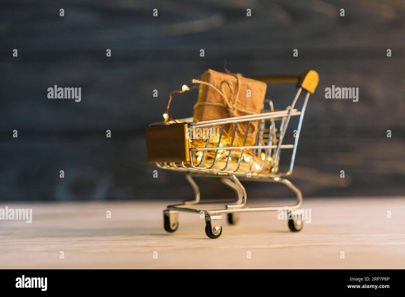 Small grocery cart with gift box Stock Photo - Alamy