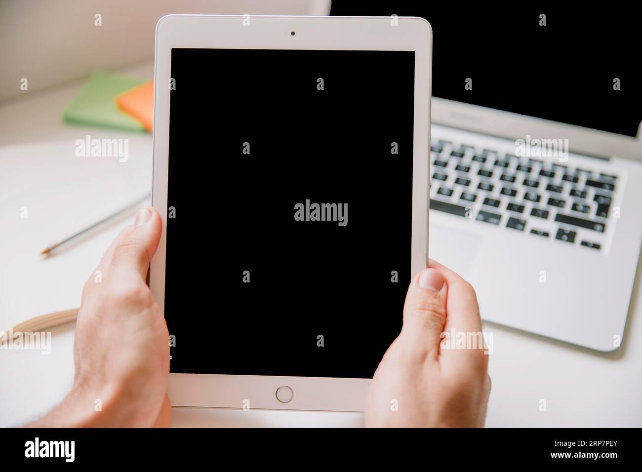 Technology desk concept with hands holding tablet Stock Photo - Alamy