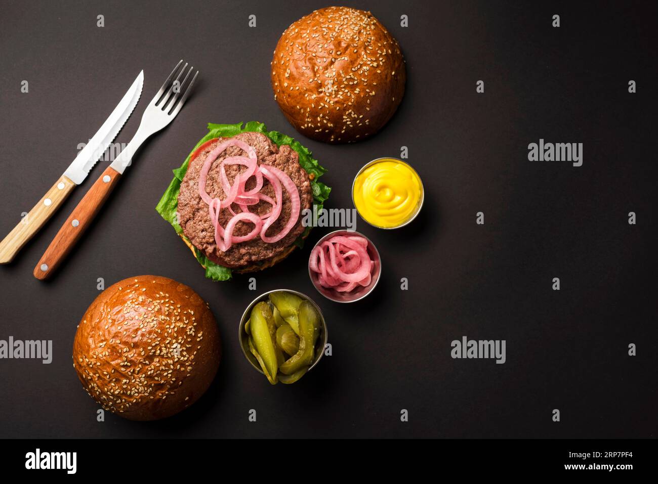 Top view beef burger with sauces cutlery Stock Photo - Alamy
