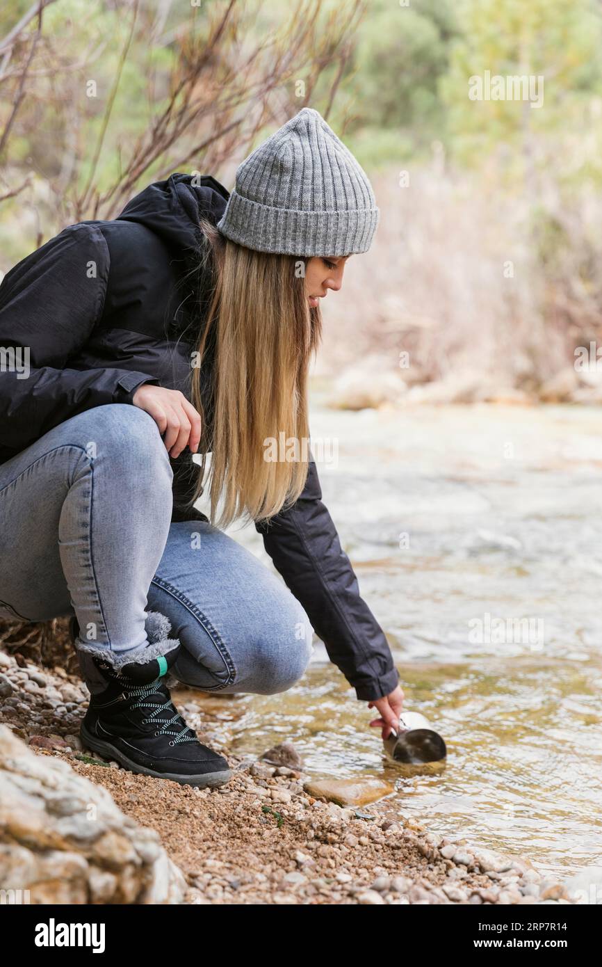 Woman nature drinking water from river Stock Photo - Alamy