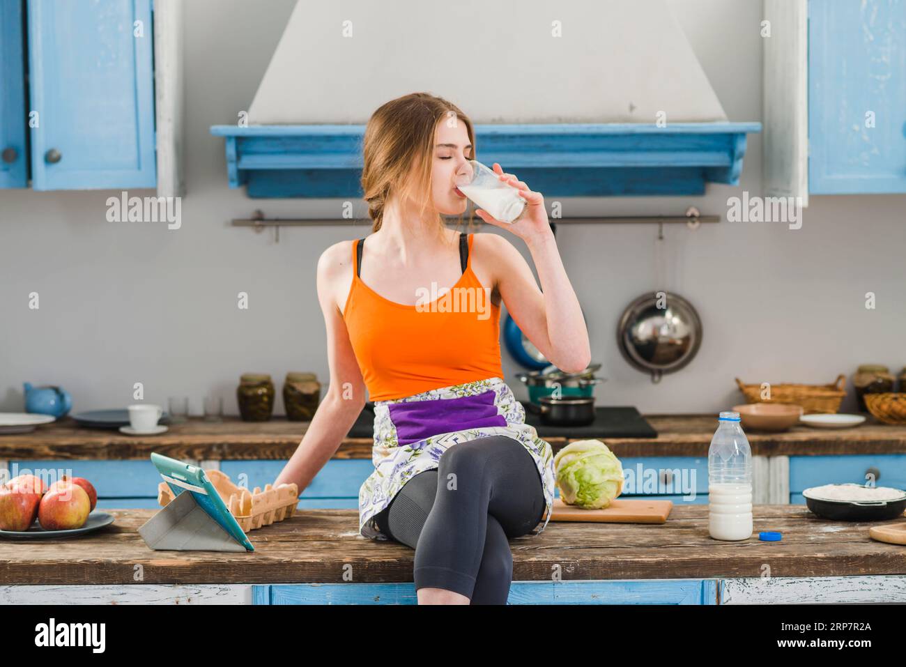 Woman drinking milk counter Stock Photo - Alamy