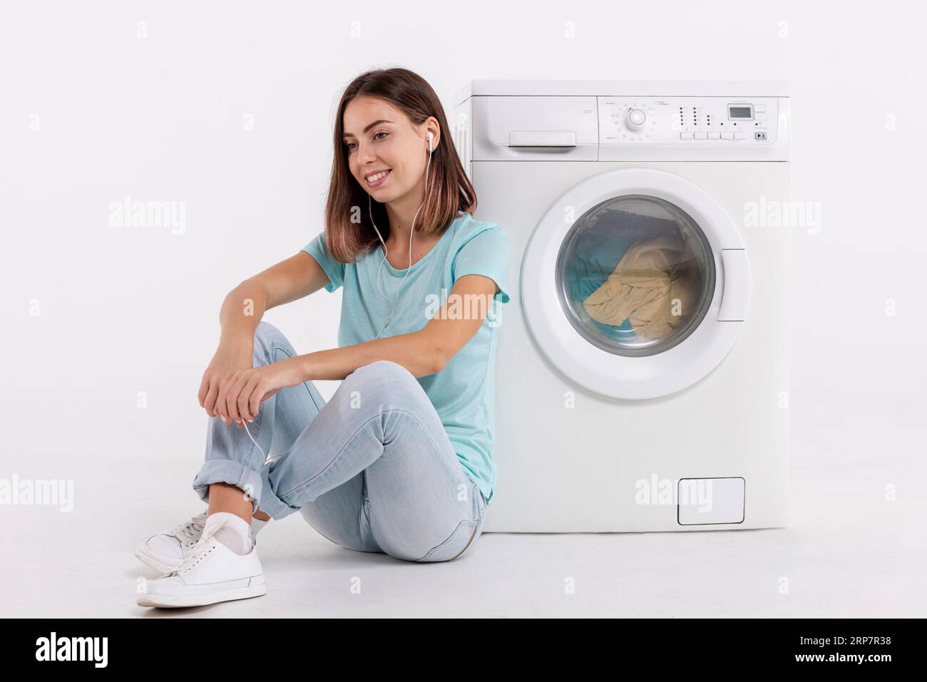 Woman listening music doing laundry Stock Photo - Alamy