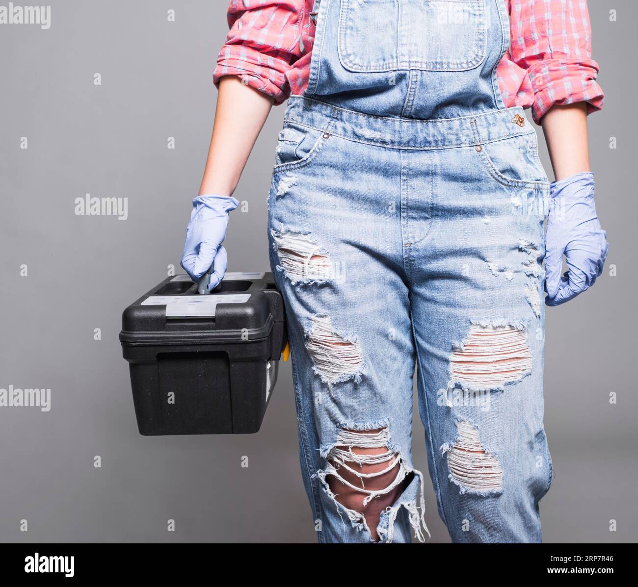 Woman overall holding tool box Stock Photo - Alamy