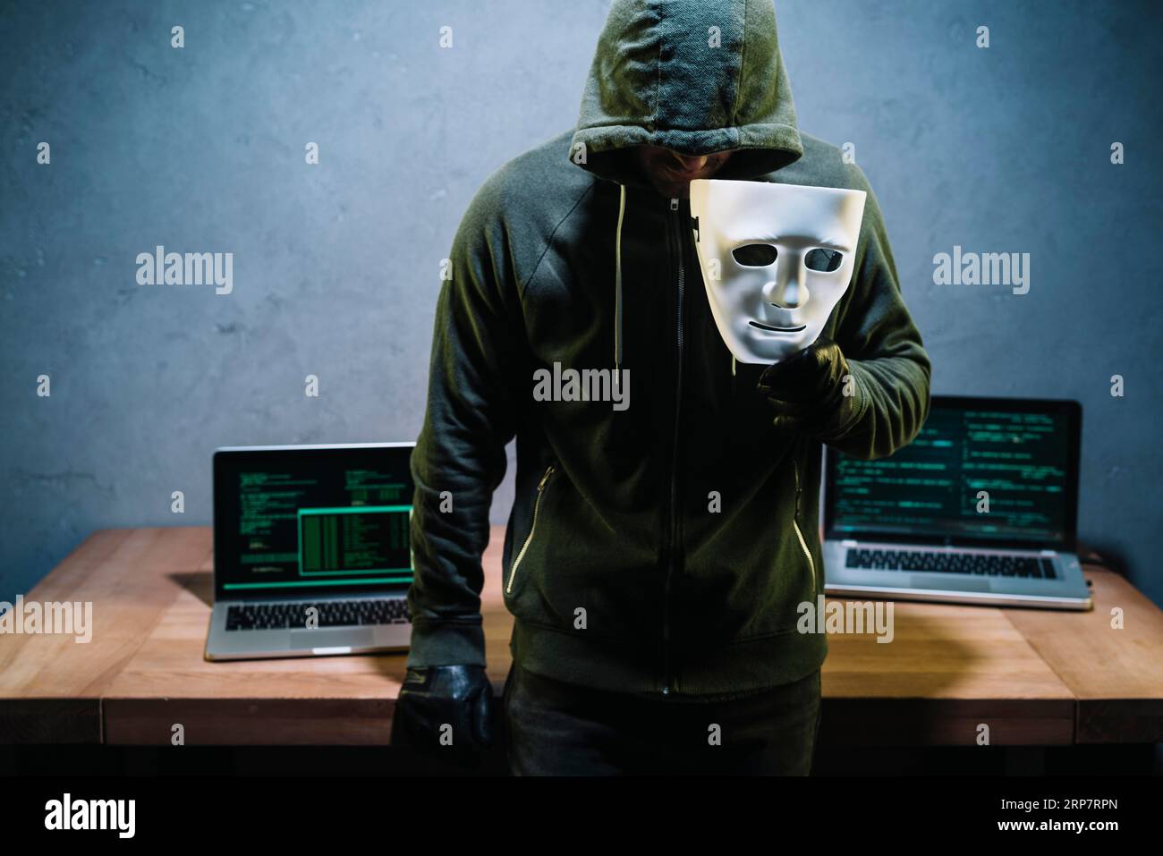 Hacker holding mask Stock Photo - Alamy
