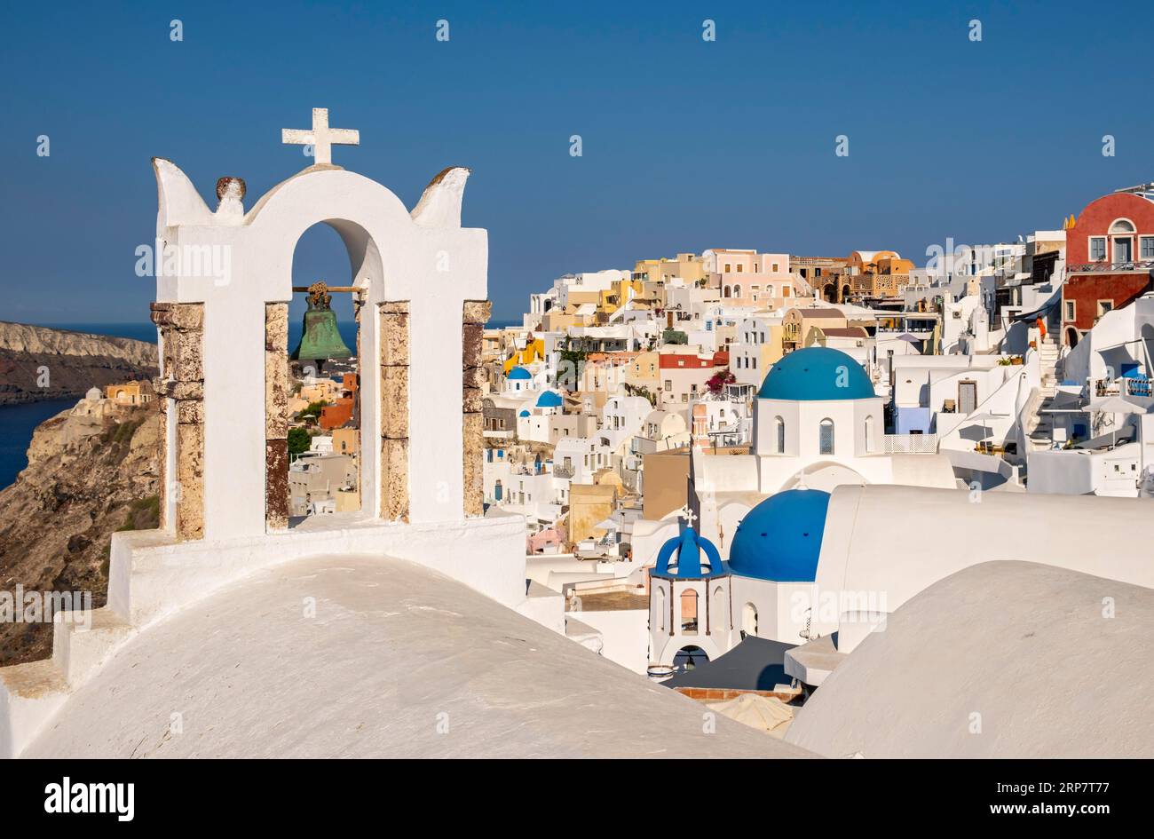 White belfry of Chapel of Saint John the Baptist and village of Ia, Oia ...