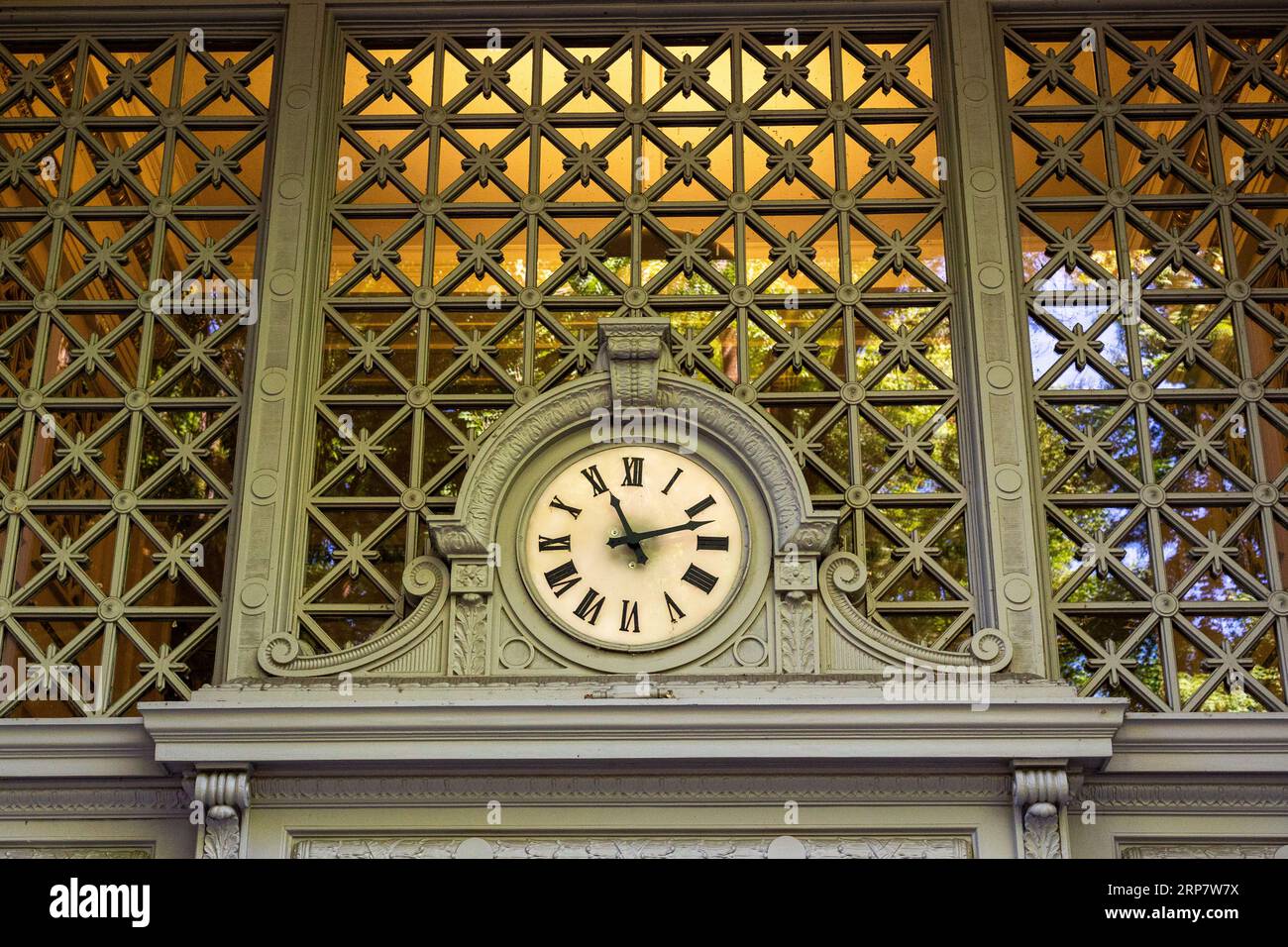 Old clock and decorative glass window in the front of a church in the ...