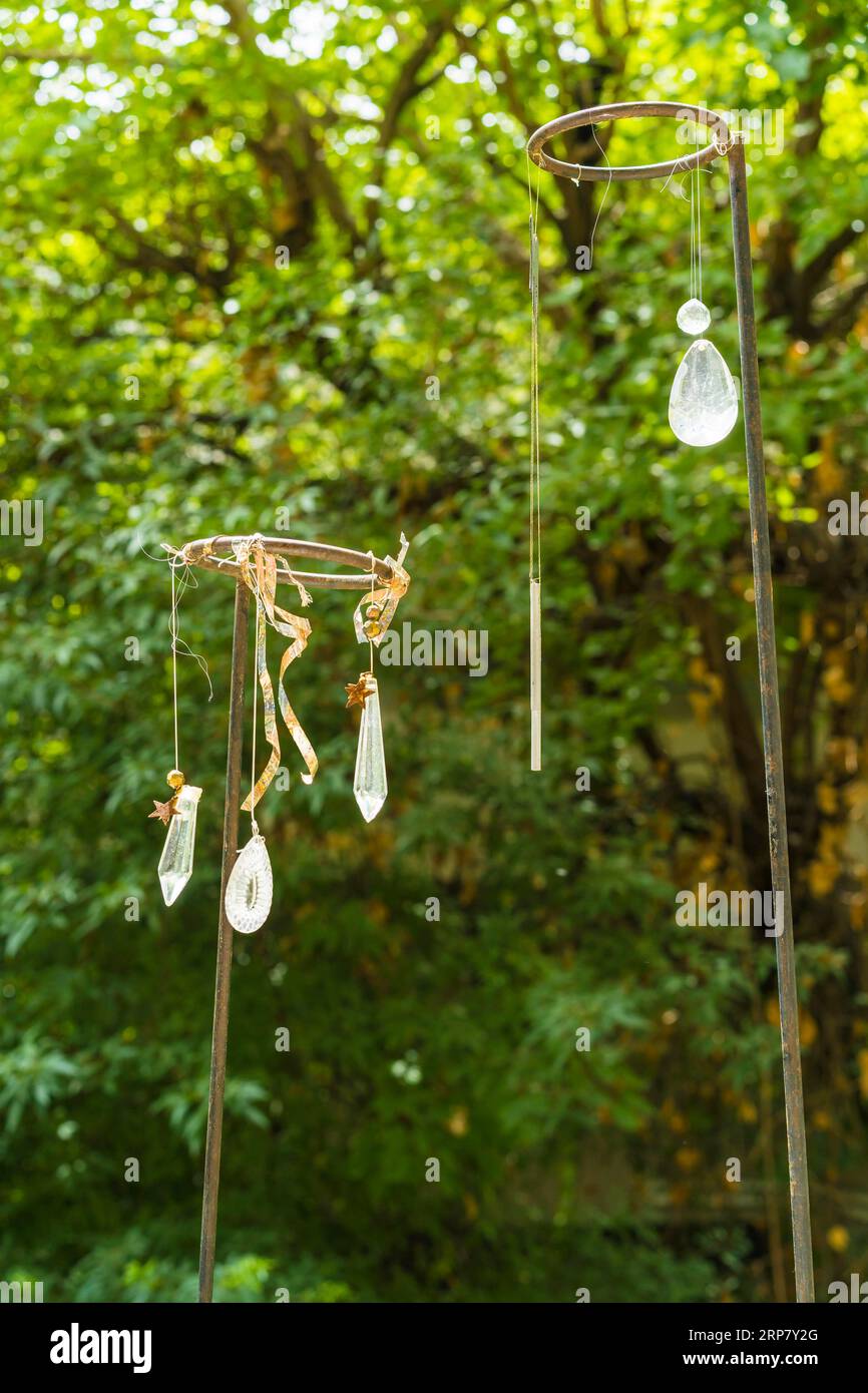 Group of white quartz crystals hanging on strings over nature ...