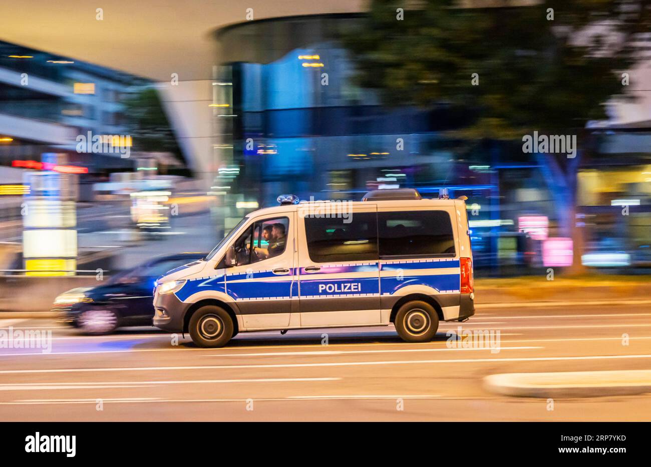 Police vehicle at night in front of urban surroundings, pull-along ...