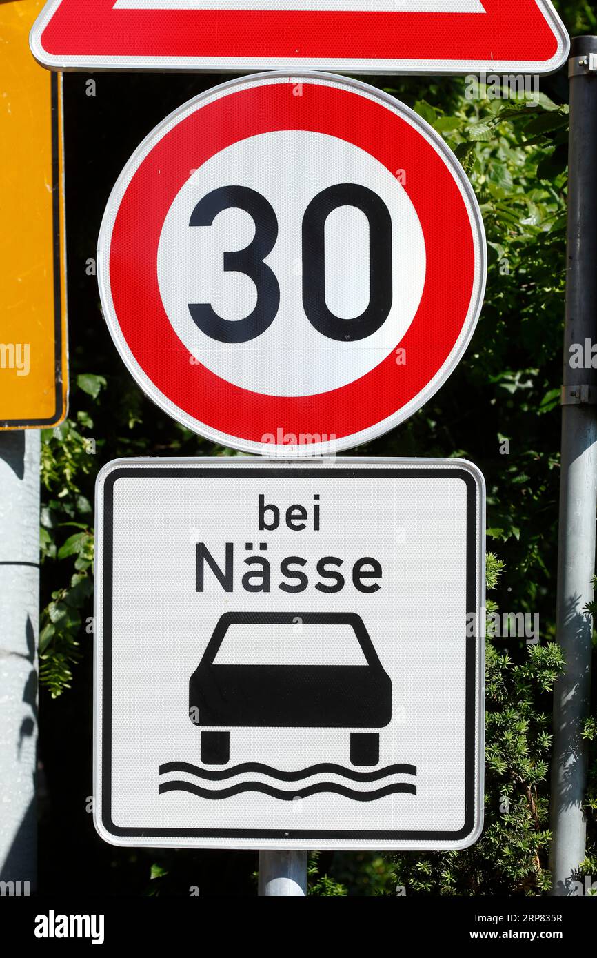 Traffic sign Permissible maximum speed 30 kilometres per hour in wet ...