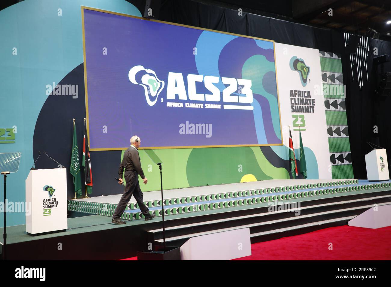 An organizer is seen walking past a display screen with the Africa ...