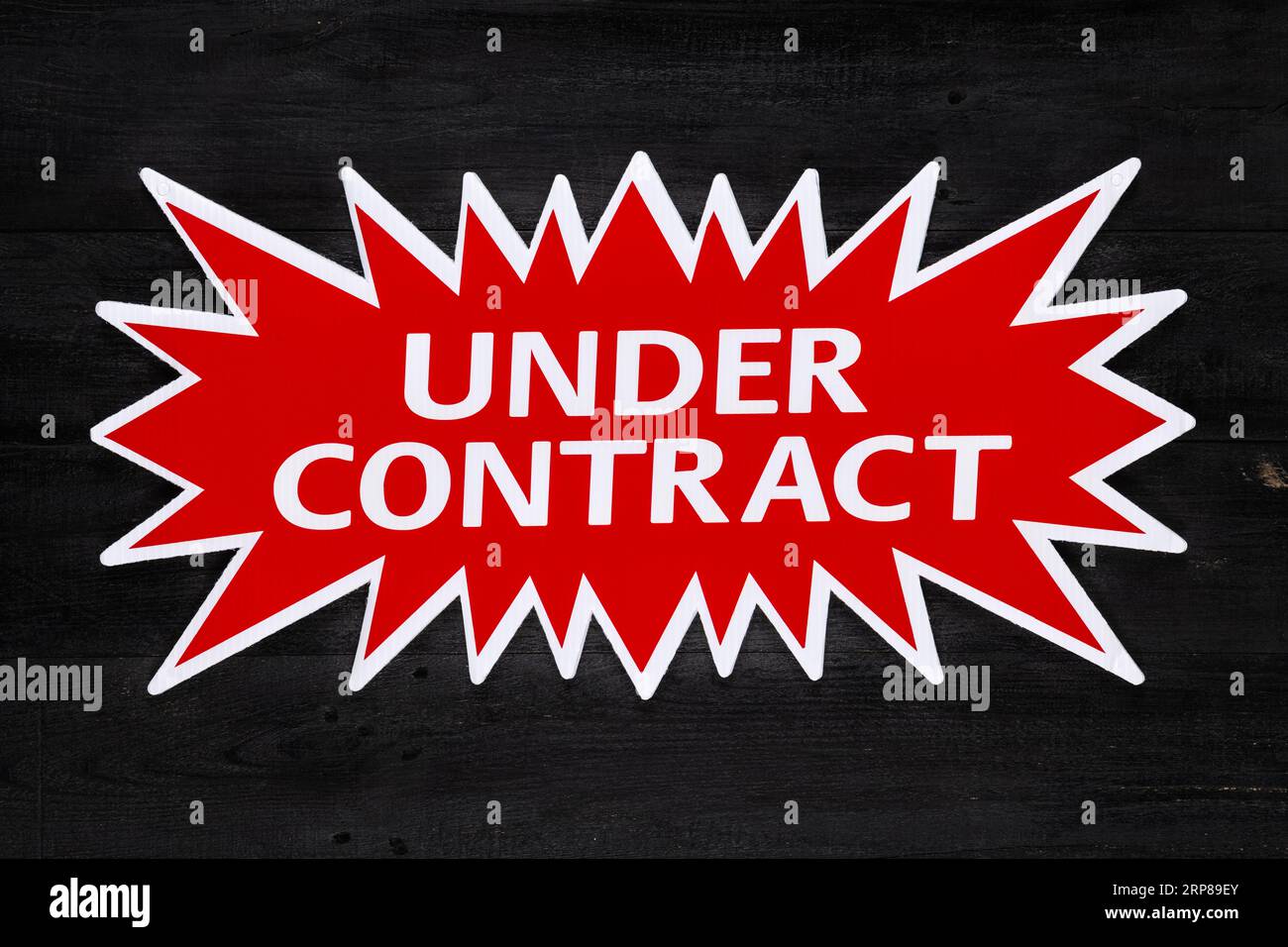 Red real estate sign with Under Contract in white on a black background ...