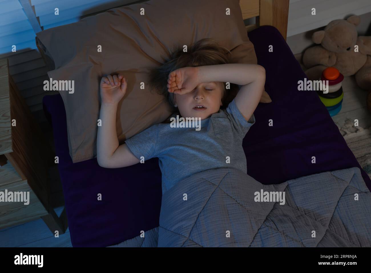 Little boy snoring while sleeping in bed at night, above view Stock ...