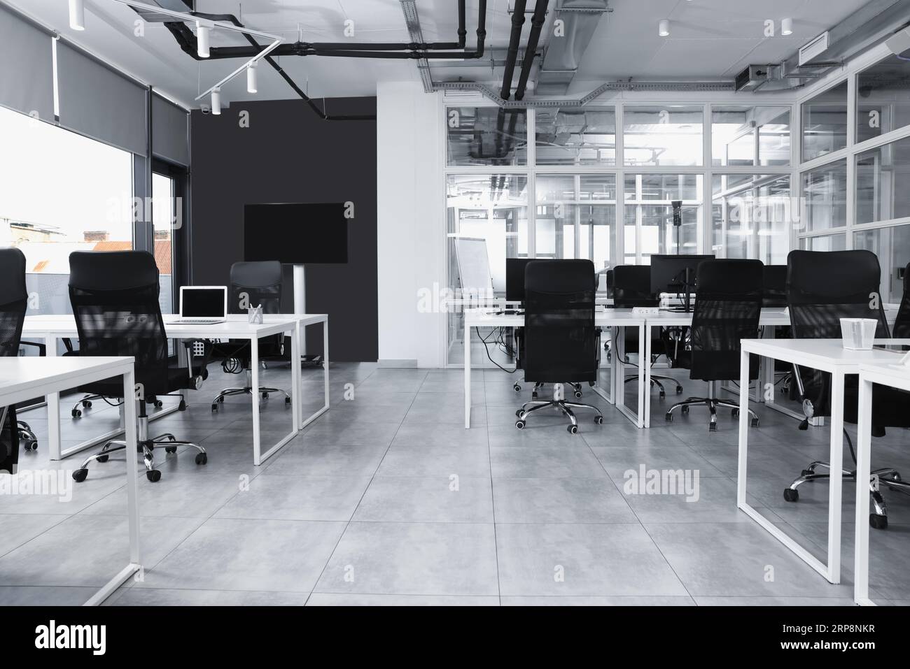 Stylish interior of open plan office. Workspace with tables and chairs ...