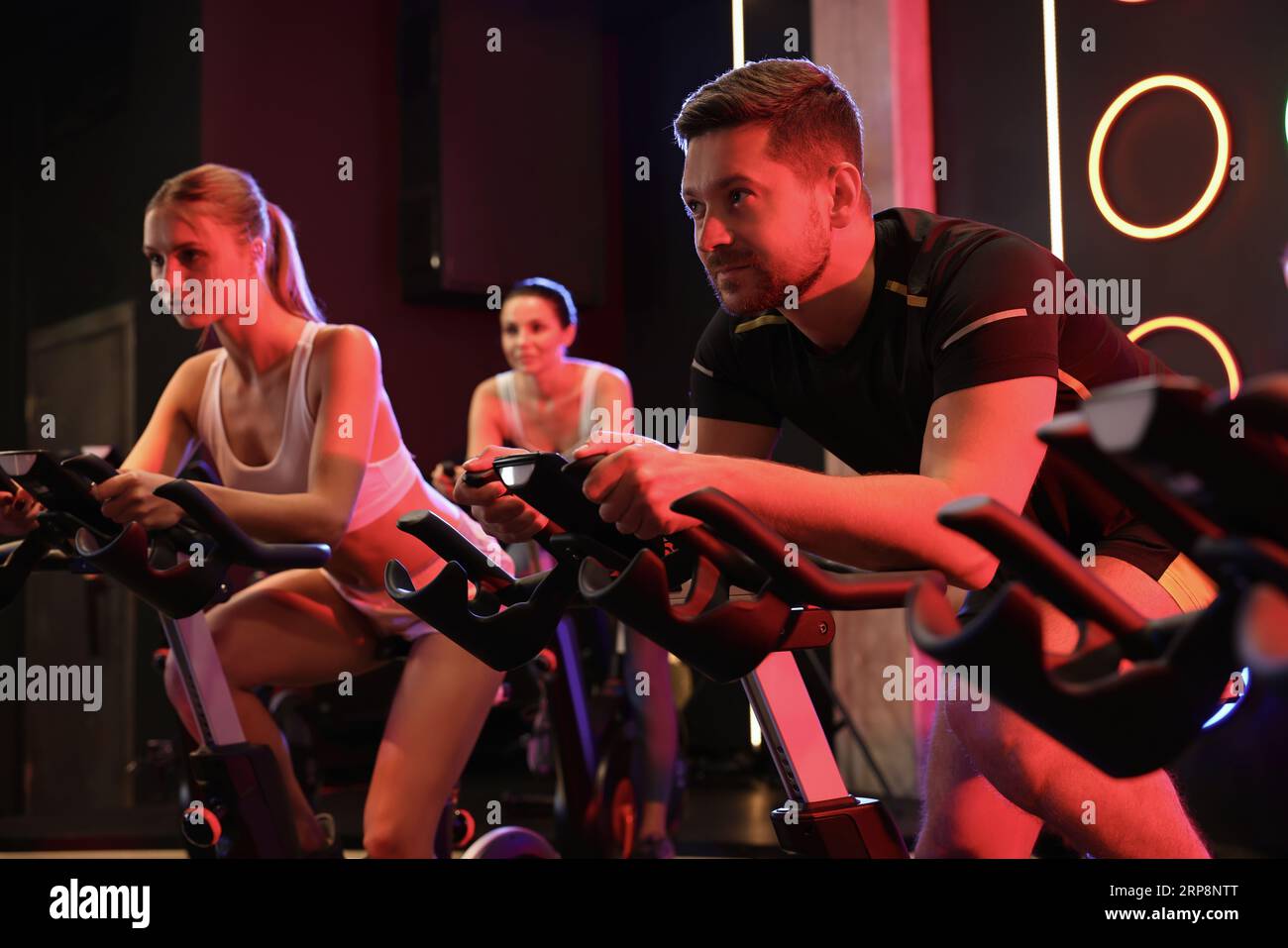 Group of people training on exercise bikes in fitness club Stock Photo ...