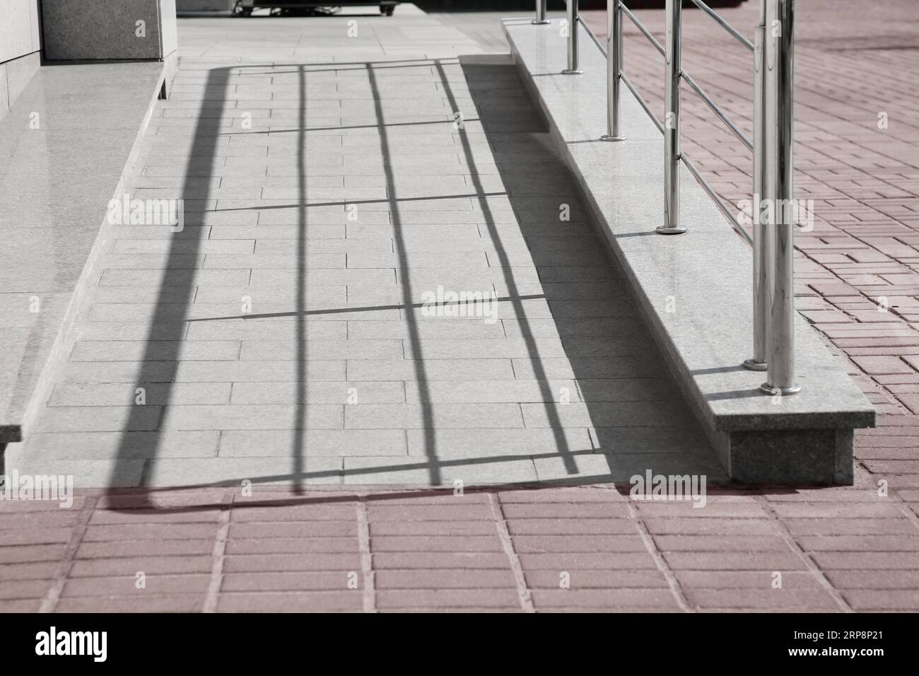Tiled ramp with metal handrail near building outdoors Stock Photo - Alamy
