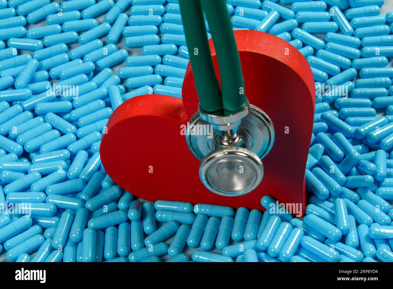 heart shape and medicine capsules representing heart problems and ...