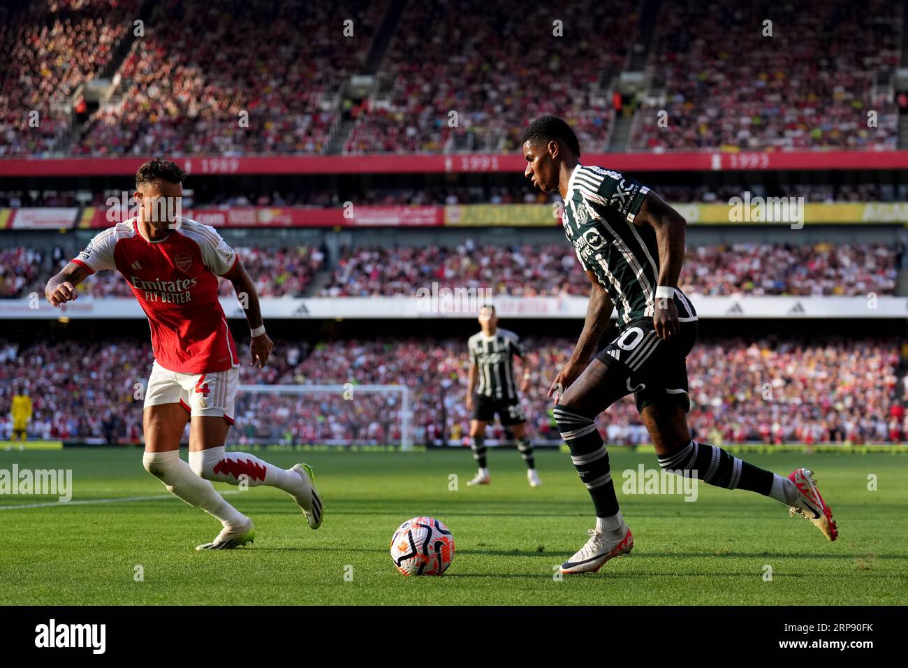 Manchester United's Marcus Rashford (right) runs at Arsenal's Ben White ...
