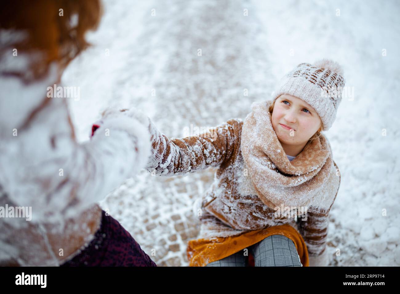 mother helping daughter getting up after falling outdoors in the city ...