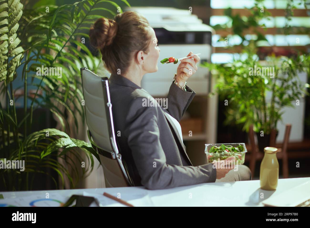 Sustainable workplace. Seen from behind female employee in a grey ...