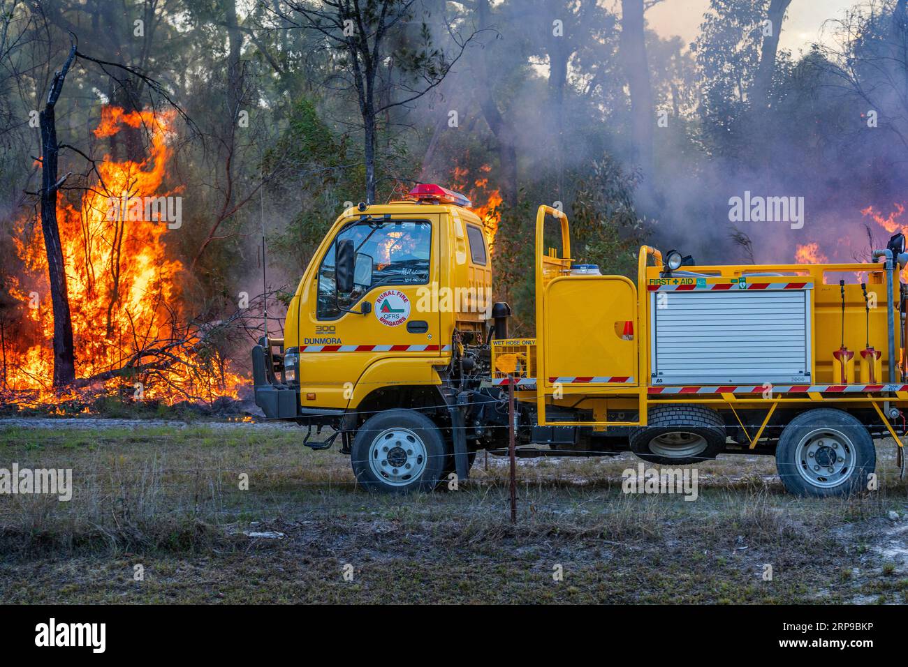 Yellow Rural Fire Service appliance with flames in background managing ...