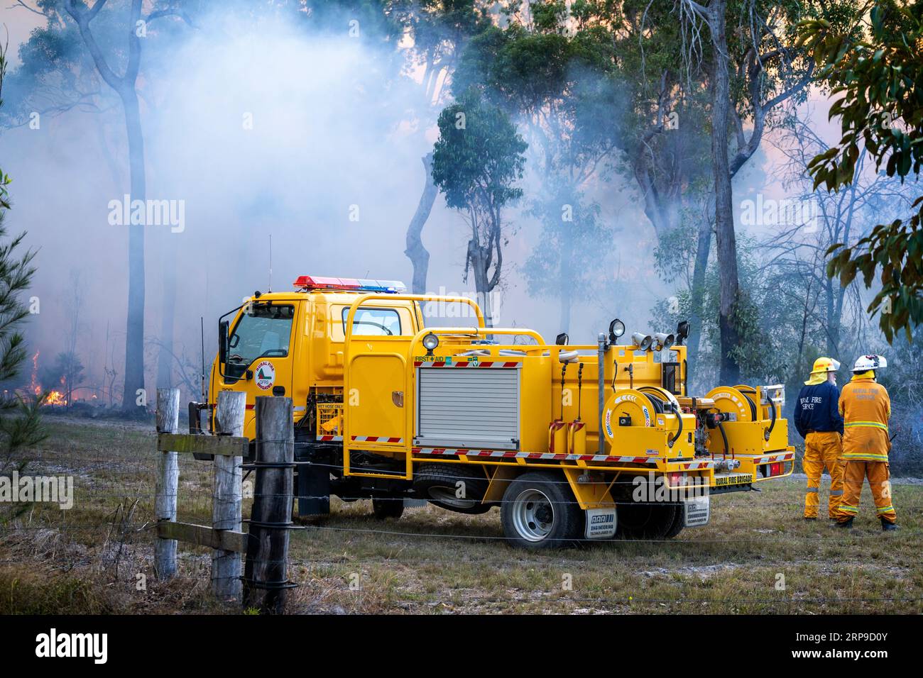Yellow Rural Fire Service appliance with flames in background managing ...