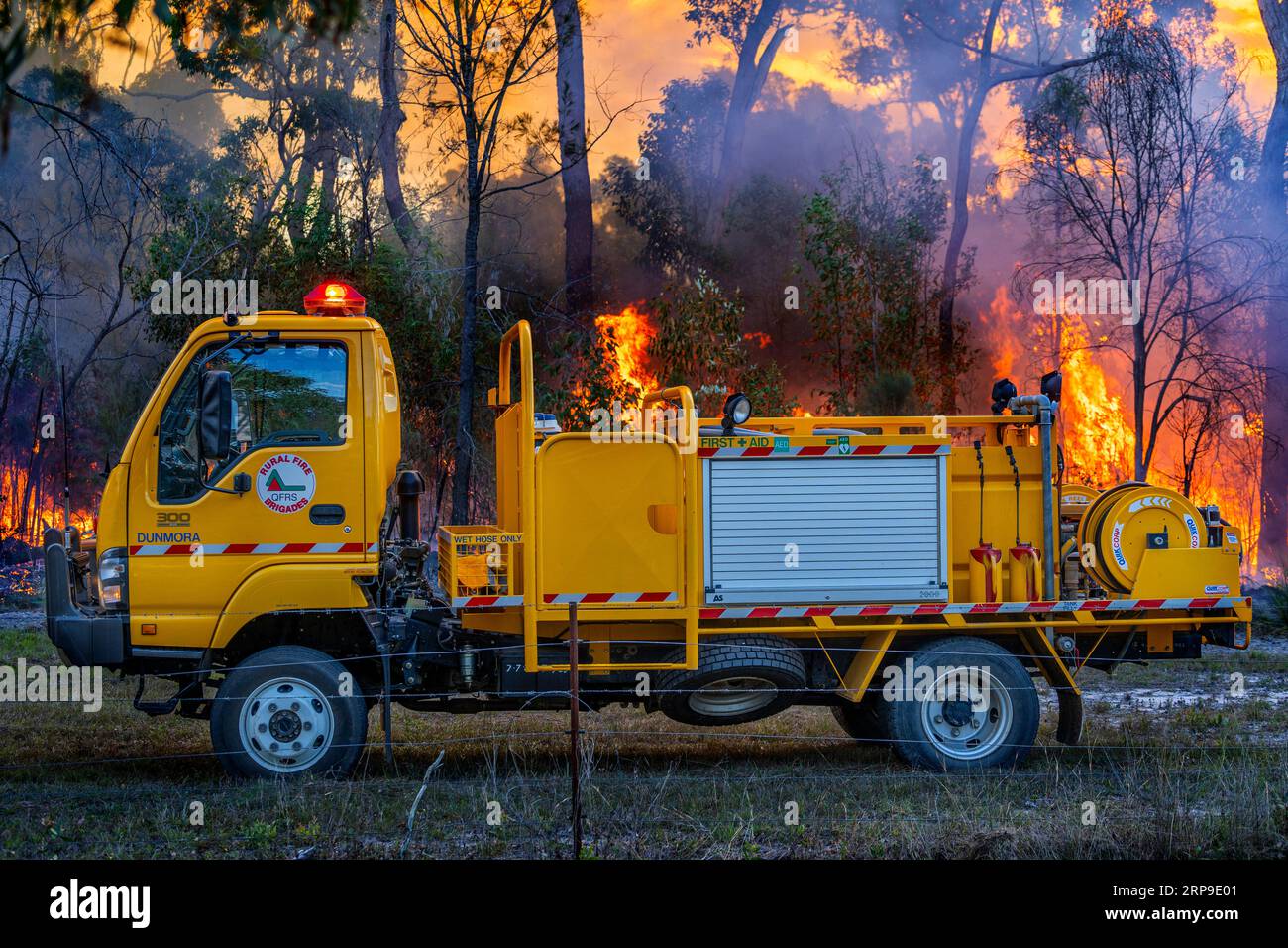 Yellow Rural Fire Service appliance with flames in background managing ...