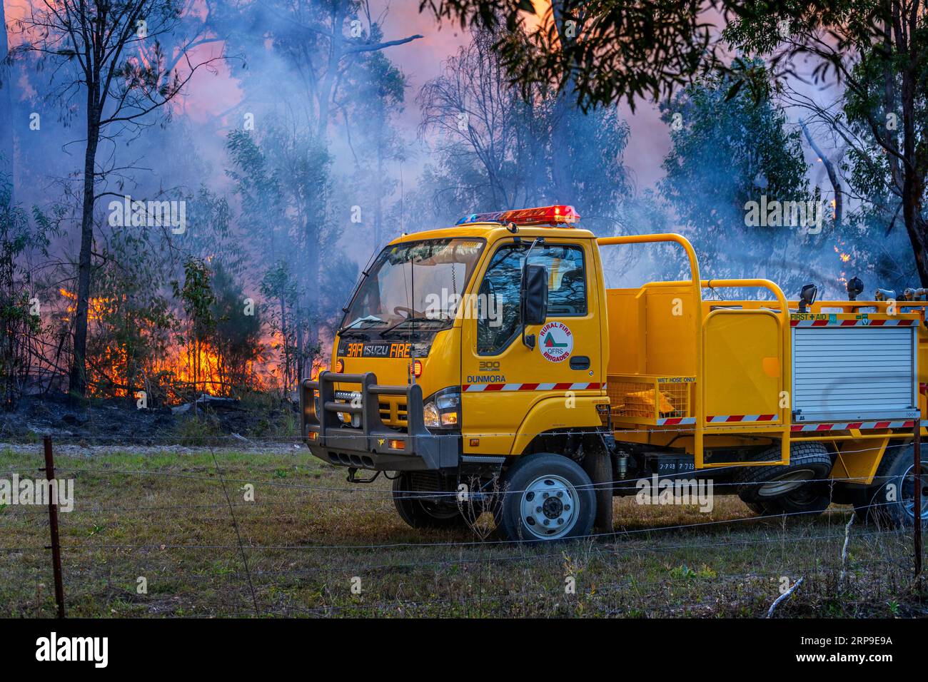 Yellow Rural Fire Service appliance with flames in background managing ...