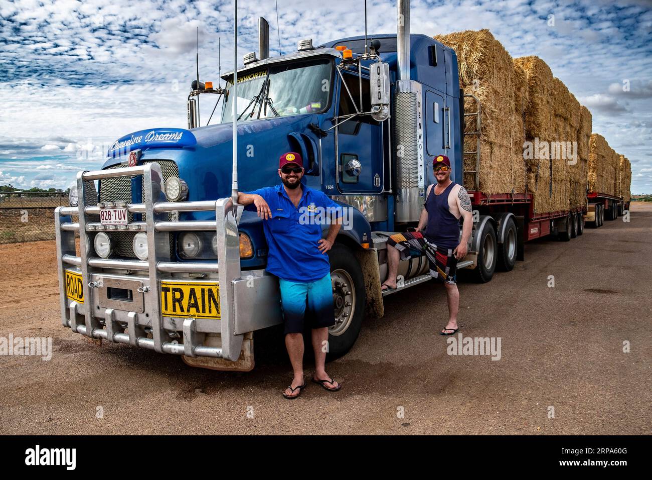 Two truck drivers delivering a load of drought relief fodder to aid ...
