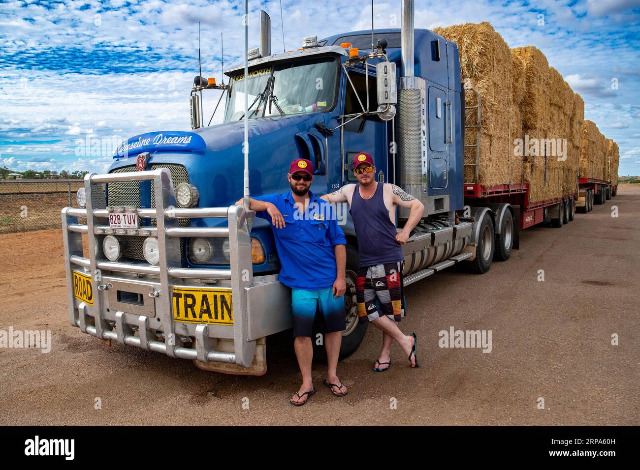 Two truck drivers delivering a load of drought relief fodder to aid ...