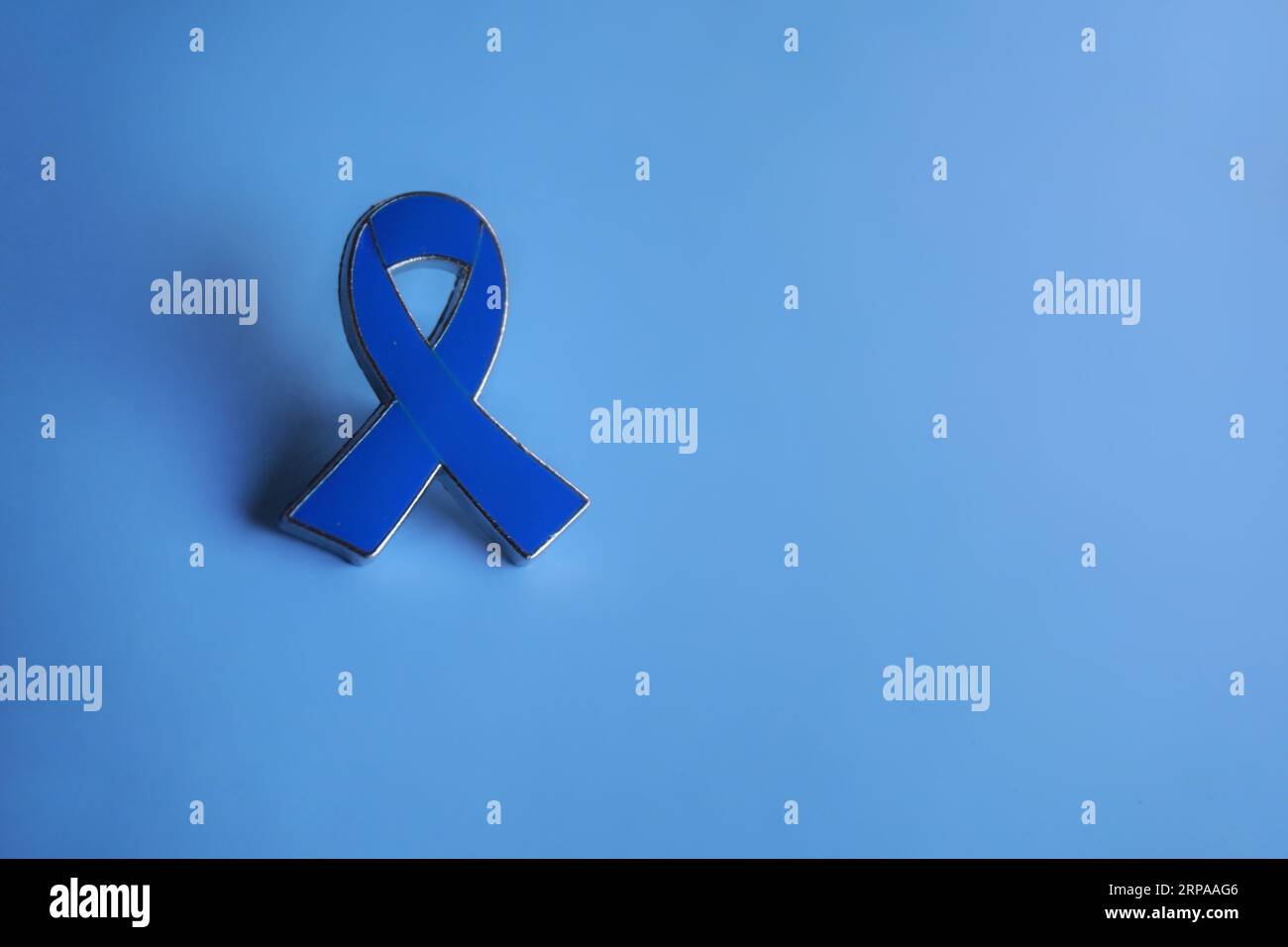 Blue ribbon on blue background with copy space. Cancer awareness ...