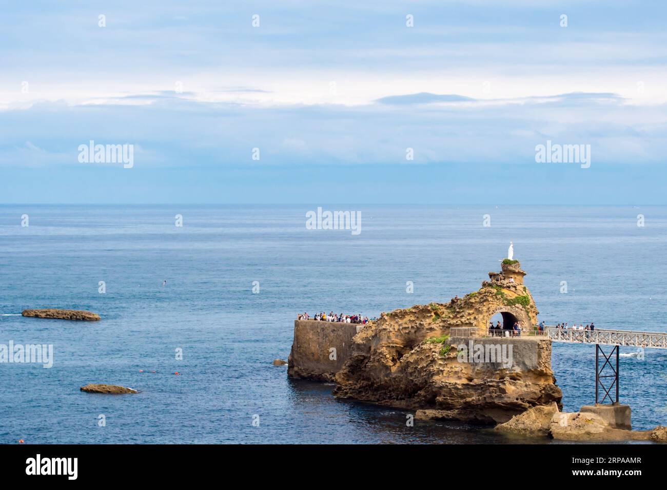 A group of people are ascending a set of stairs located next to a white ...