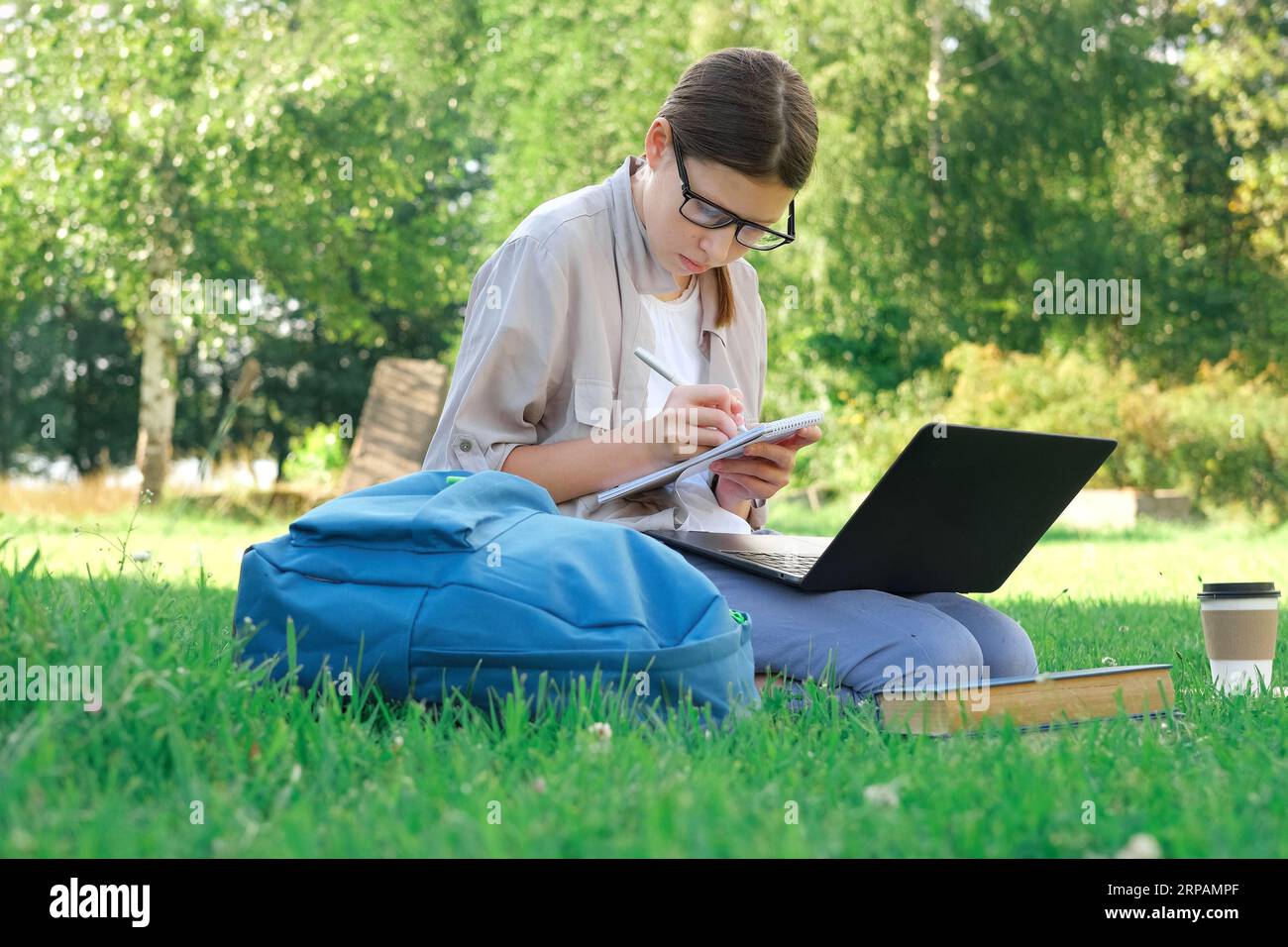 Teenage schoolgirl studying reading her books, tablet and notebook ...