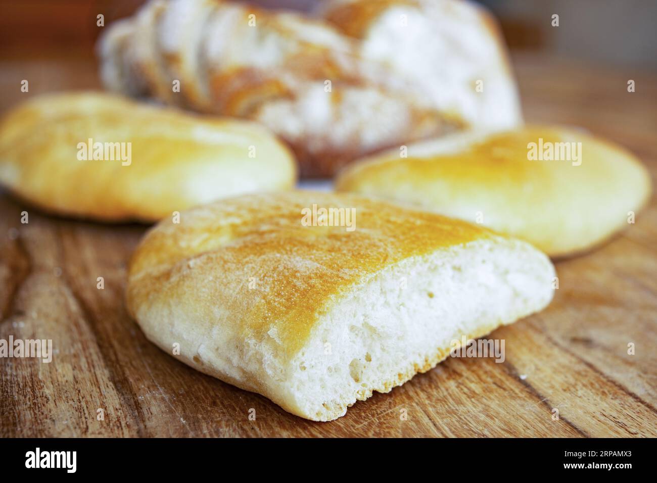 sliced bread and rolls placed on a cutting board Stock Photo - Alamy