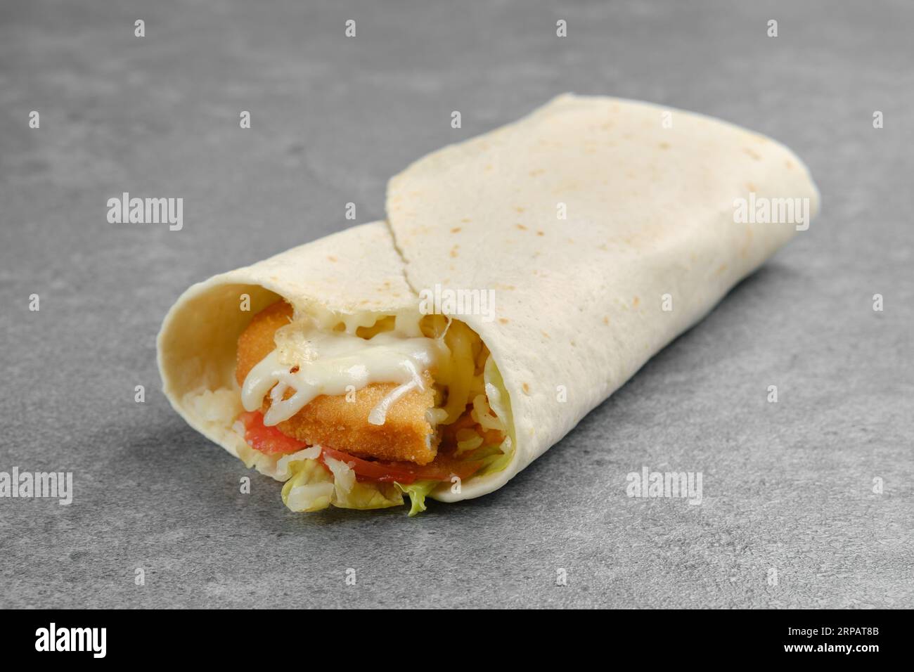 Flatbread stuffed with fish patty in breading with melted cheese and ...