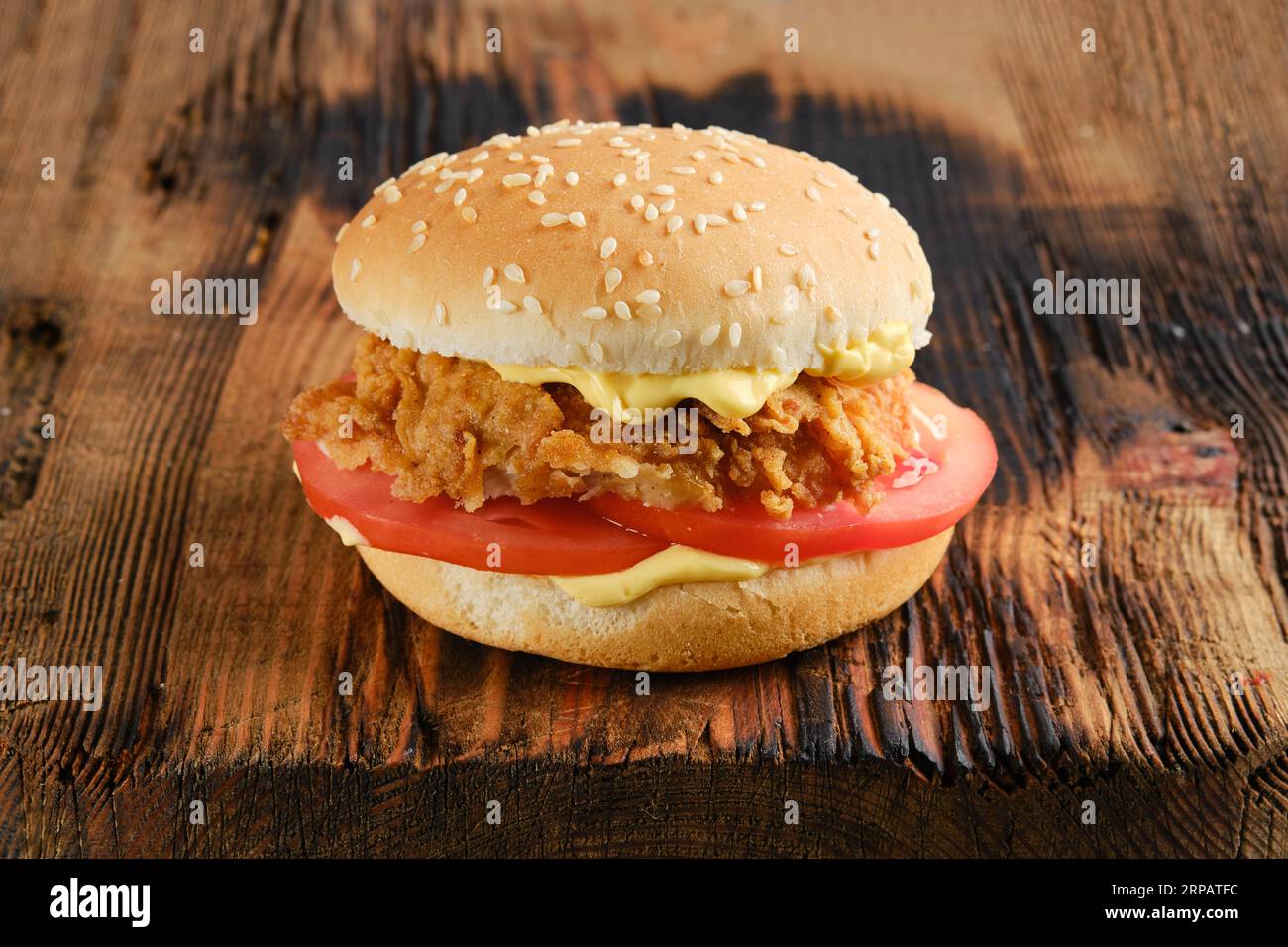 Street chicken burger with fresh tomato and cheesy sauce Stock Photo ...