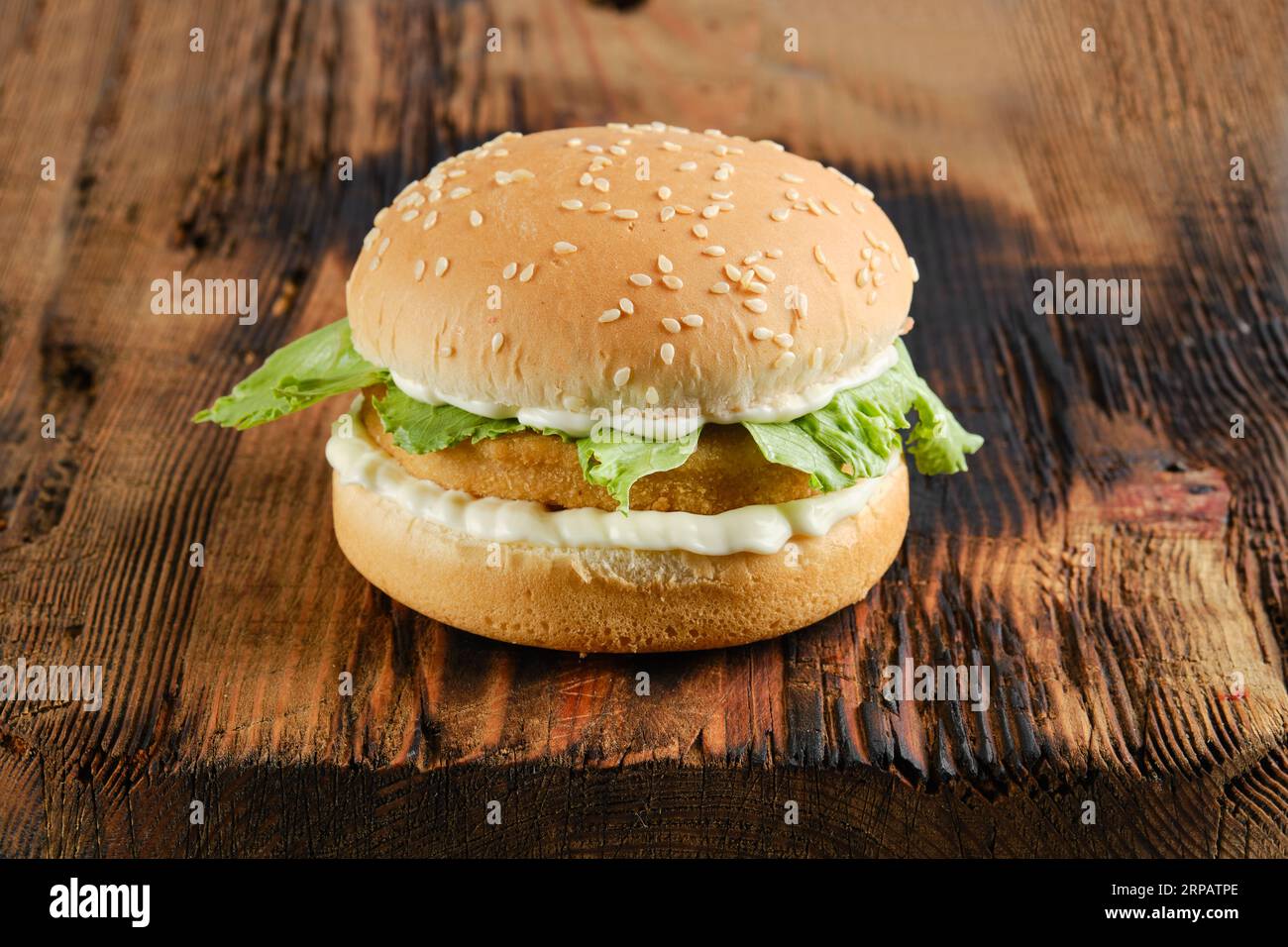 Chicken burger with fresh iceberg lettuce salad on wooden board Stock ...