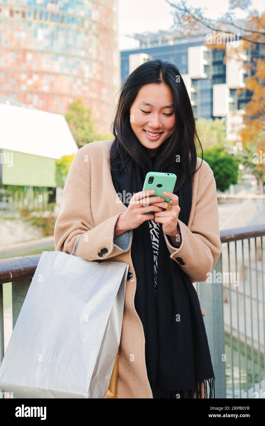 Vertical individual portrait of one happy chinese girl using a ...