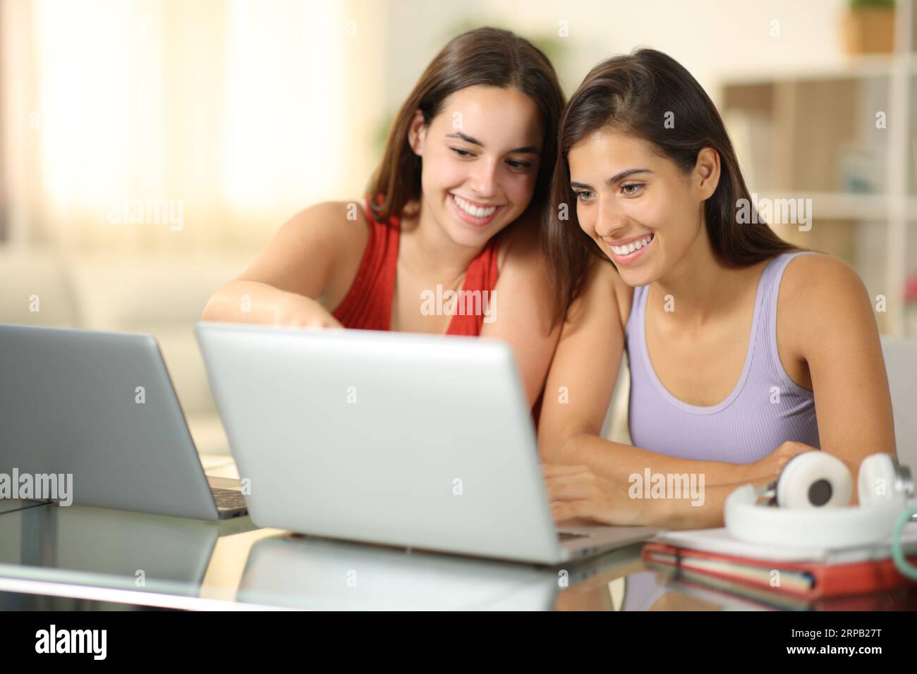 Happy students e-learning with laptops at home Stock Photo - Alamy
