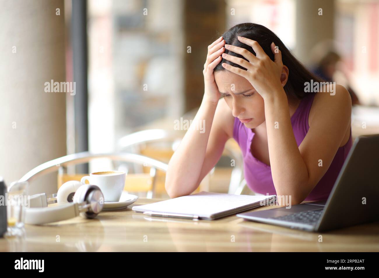 Sad student trying to learn reading notes and complaining in a bar ...