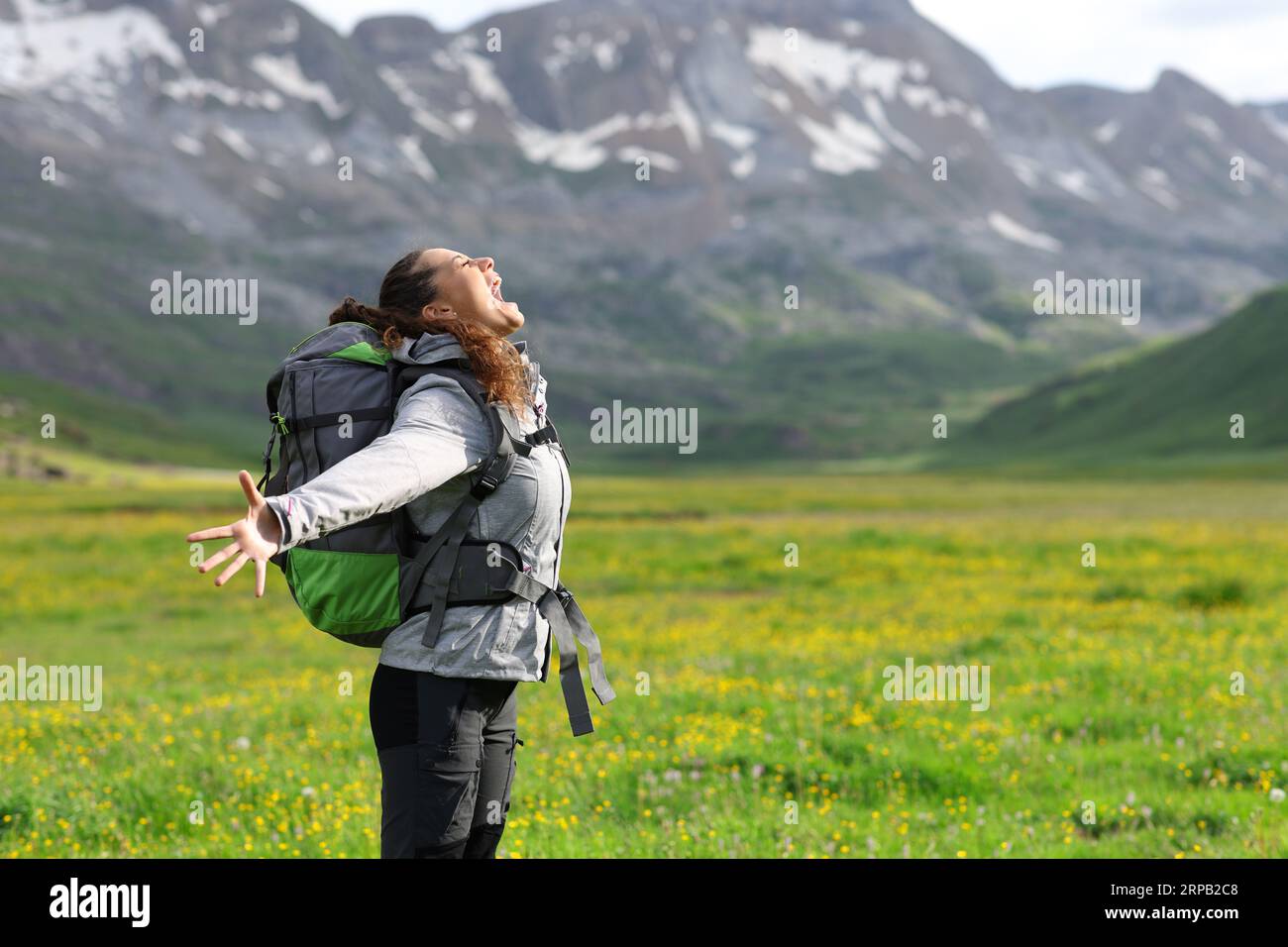 Profile of a happy hiker screaming and outstretching arms in nature ...