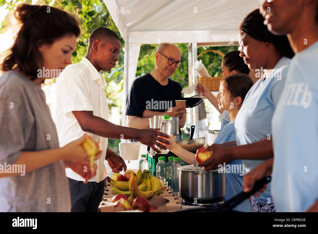 Diverse group of female volunteers donate free food to the poor and ...