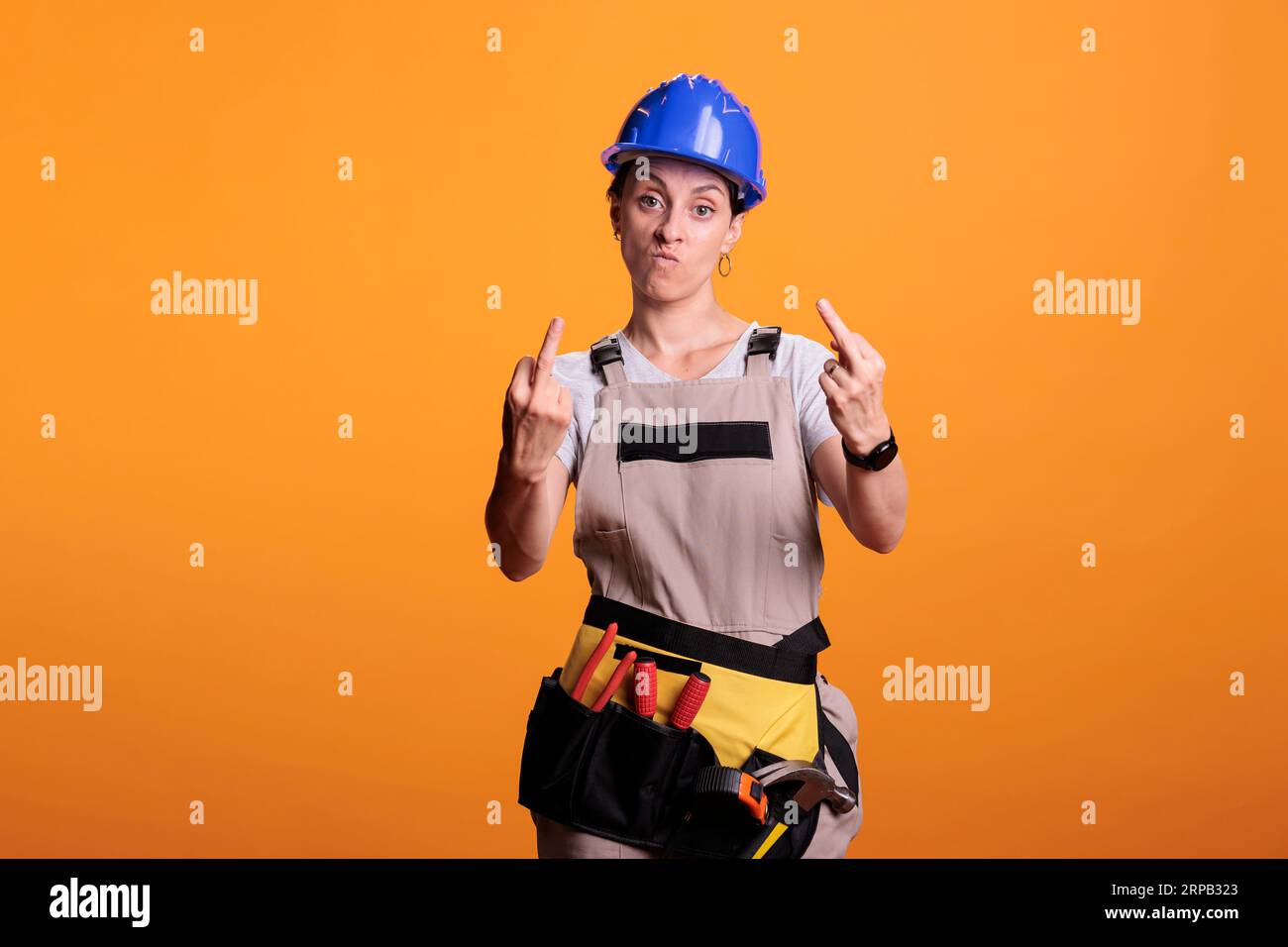 Bad construction worker showing middle finger in studio, doing rude ...