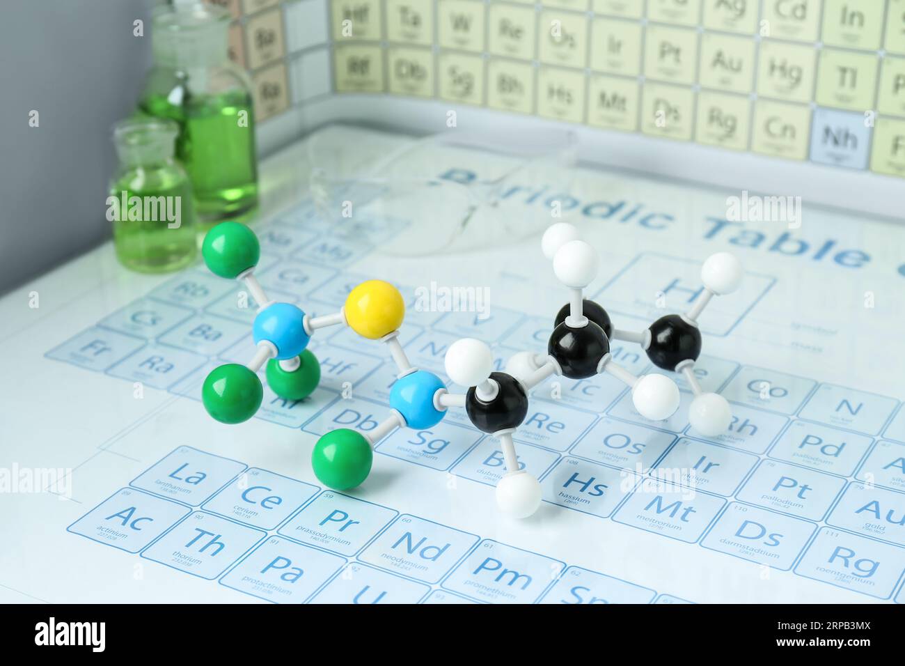 Molecular model and laboratory glassware on periodic table Stock Photo ...