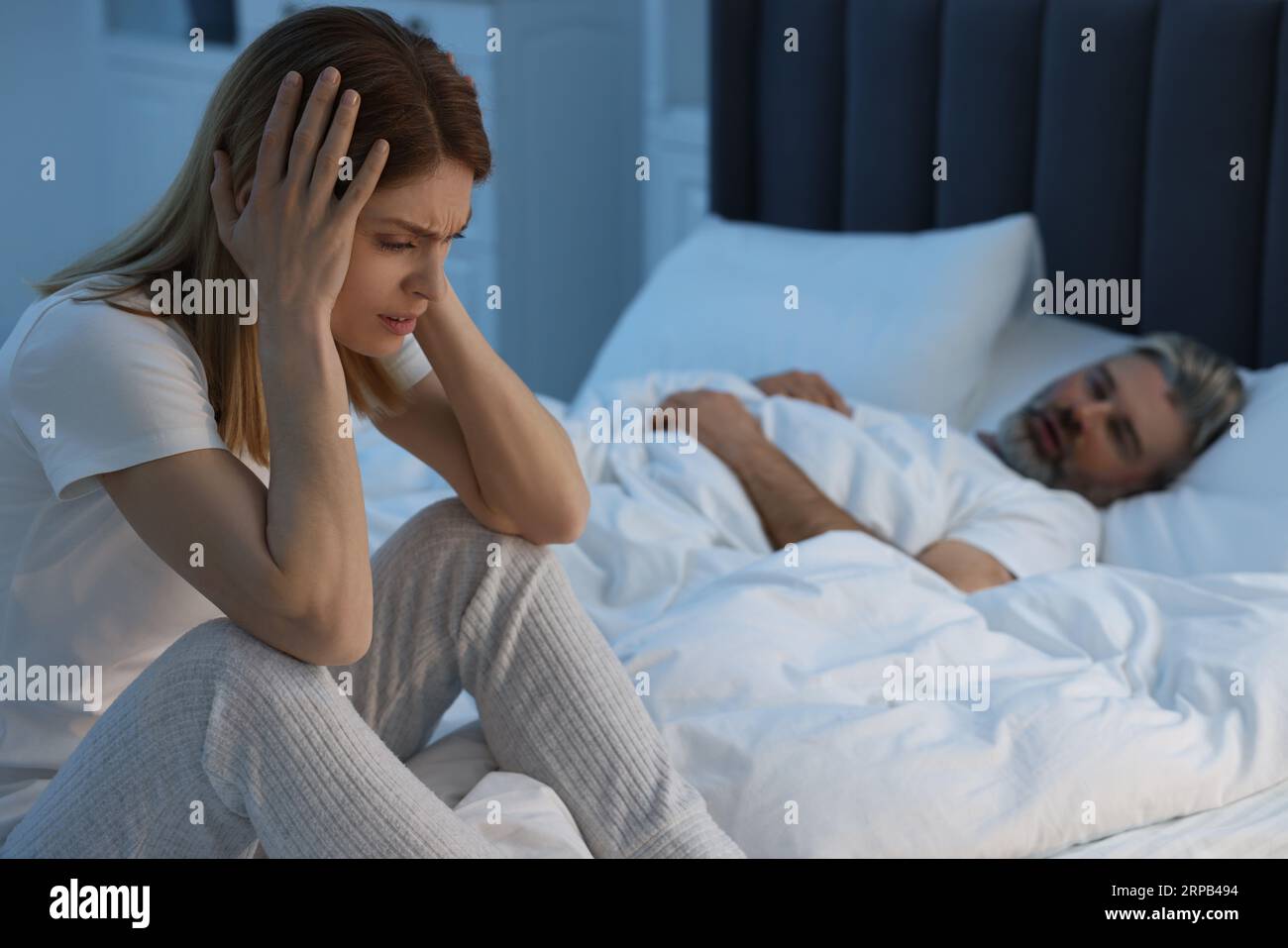 Woman covering ears in bed hi-res stock photography and images - Alamy