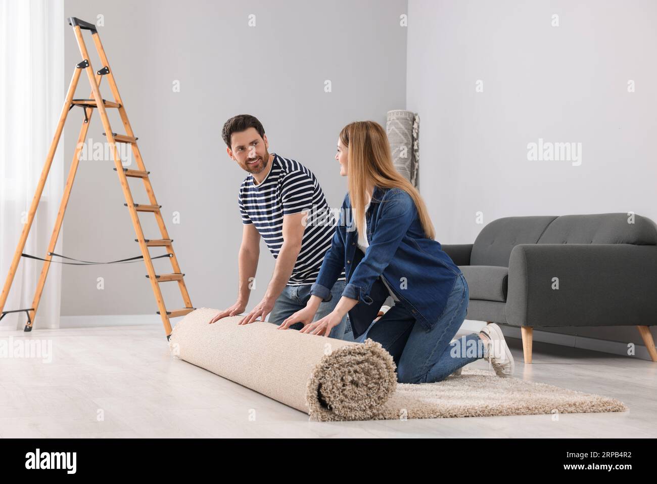 Family unrolling new rug hi-res stock photography and images - Alamy
