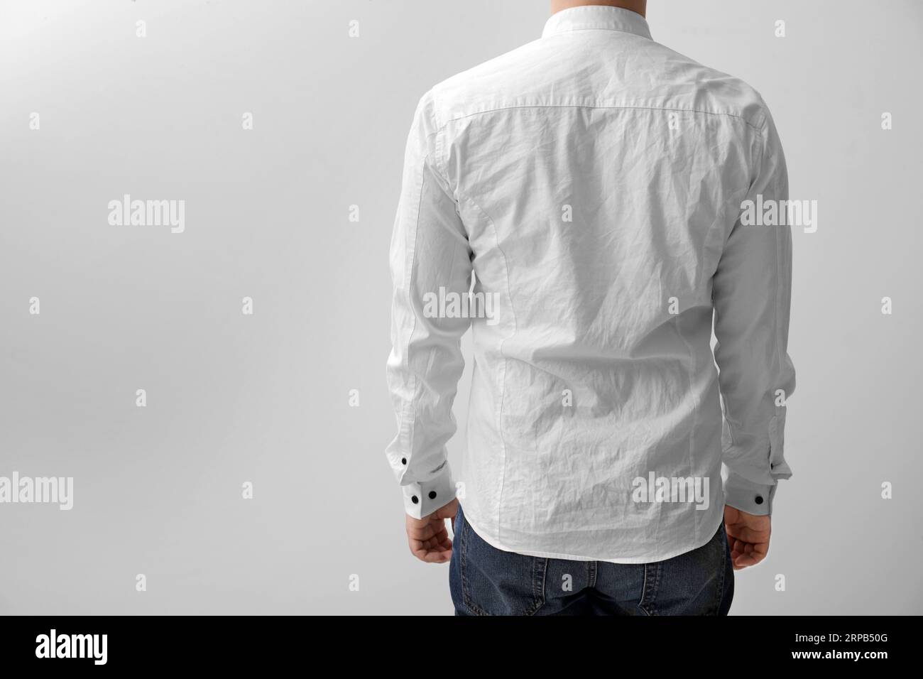 Man wearing rumpled shirt on white background, back view Stock Photo ...