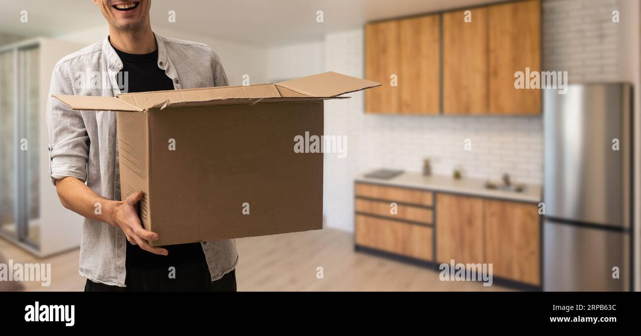 Man lifting cardboard boxes in apartment interior Stock Photo - Alamy